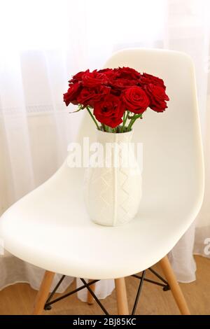 Red roses on chair beside window with curtain Stock Photo - Alamy