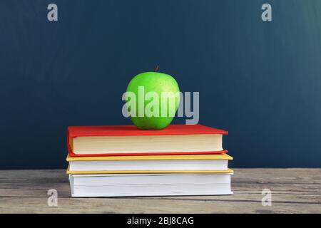 Few books with green apple on table Stock Photo - Alamy