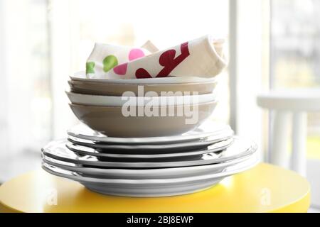 Clean dishes on wooden table on green background Stock Photo - Alamy