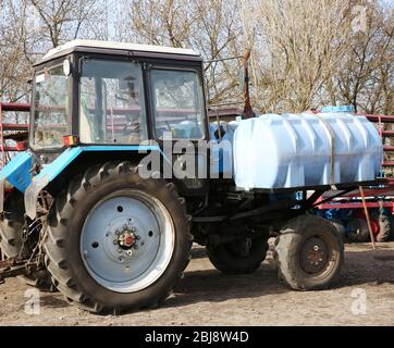 watering cans at farm water tank Stock Photo - Alamy
