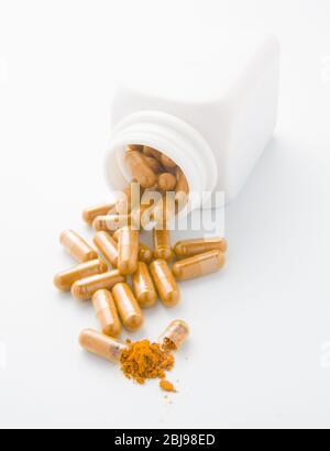 turmeric herb capsule from bottle on white background Stock Photo - Alamy