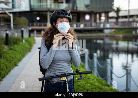 Woman putting on bike helmet Stock Photo - Alamy