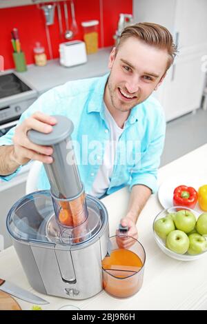 Handsome man making juice in kitchen Stock Photo - Alamy