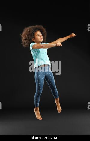 Happy African girl jumping on black background Stock Photo - Alamy