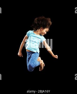 Happy African girl jumping on black background Stock Photo - Alamy