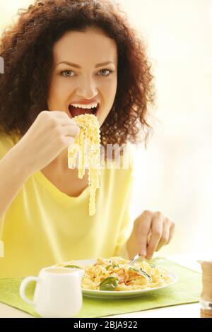 Woman eating delicious pasta in restaurant Stock Photo - Alamy