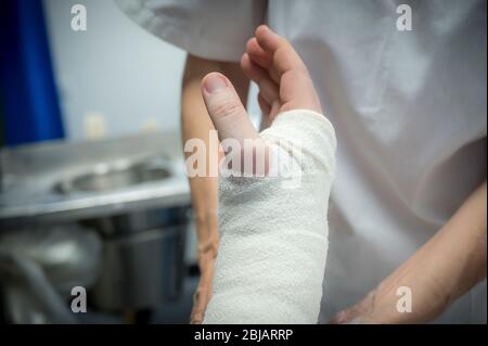 Nurse plastering a patient's arm in a hospital in an accident and ...