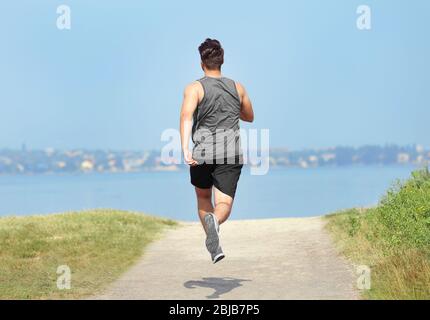 Man jogging on river background Stock Photo - Alamy