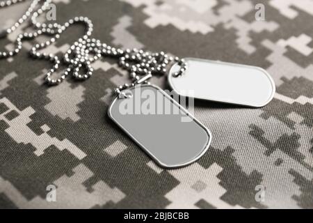 Army tokens on military uniform background Stock Photo - Alamy