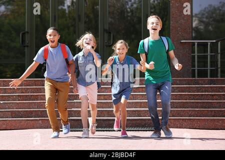 Cute kids running out of school Stock Photo - Alamy