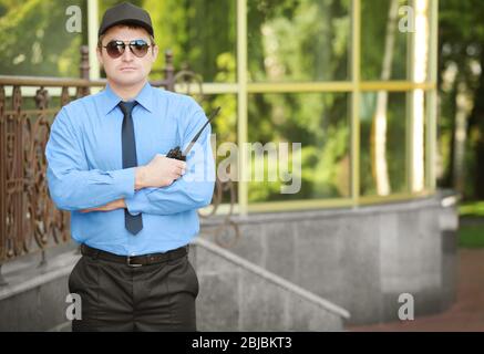 Male security guard near glass building facade Stock Photo - Alamy