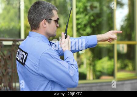 Male security guard near glass building facade Stock Photo - Alamy