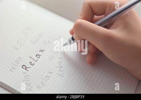 Female hand writing word "relax" in day planner, close up view Stock ...
