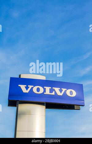 Volvo brand logo on bright blue sky background located on its sale ...