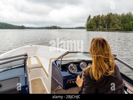 Young woman driving a motorboat Stock Photo - Alamy