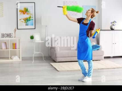 Funny adult woman with duster and detergent in living room Stock Photo ...