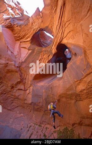 man rappelling into cave at Escalante's giant staircase Stock Photo - Alamy