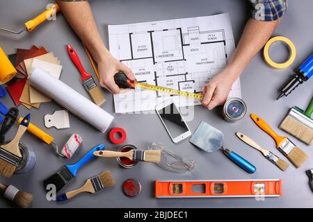 Decorator's hands with phone. Project drawing, color swatches and paint ...
