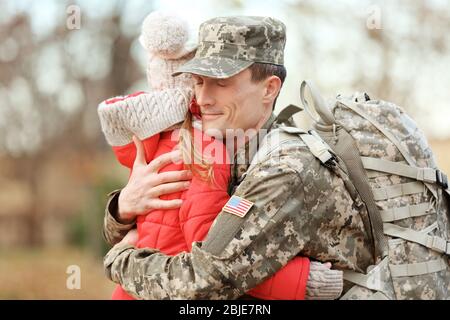 Soldier in camouflage hugging his daughter on white background Stock ...