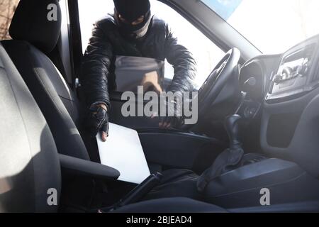 Thief stealing tablet from car Stock Photo - Alamy