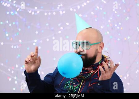 Funny fat man inflating balloon at birthday party Stock Photo - Alamy