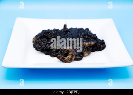 Home-cooked black risotto, a rice dish made with seafood. The dish is ...