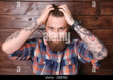 Bearded man posing on wooden background Stock Photo - Alamy