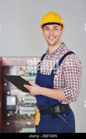 electrician with clipboard at electric board Stock Photo - Alamy