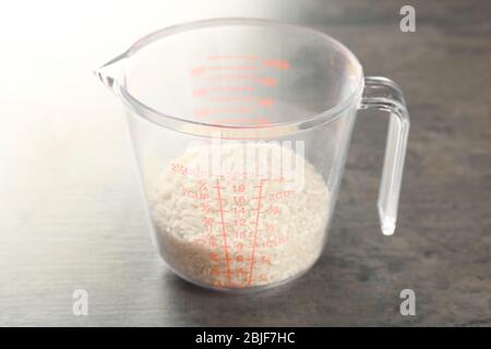 Uncooked rice and measuring jug Stock Photo - Alamy