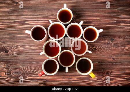 Delicious tea in cups forming star on wooden background Stock Photo - Alamy