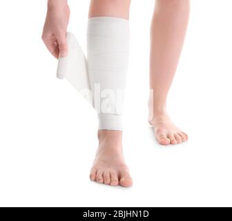Young woman applying bandage onto leg, on white background Stock Photo ...