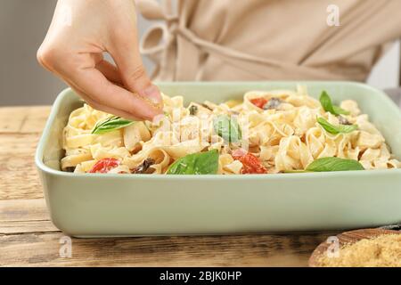 Woman cooking delicious turkey tetrazzini in kitchen Stock Photo - Alamy