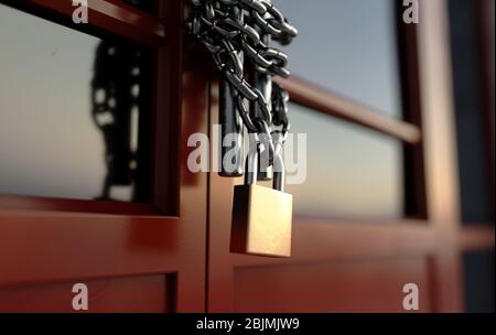 A red generic storefont door chained shut and locked with a chain an ...