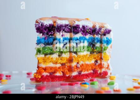 Tasty rainbow cake with caramel topping on glass stand Stock Photo - Alamy