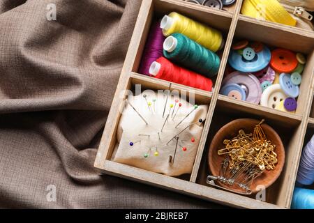 Storage box with set of tailoring items on fabric, top view Stock Photo ...