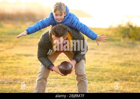 Father with little son playing rugby outdoors Stock Photo - Alamy