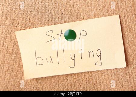 Note with text STOP BULLYING pinned on board Stock Photo - Alamy