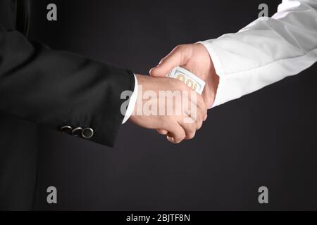 Doctor taking bribe from businessman on black background Stock Photo ...