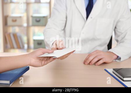Doctor taking bribe from woman at workplace Stock Photo - Alamy
