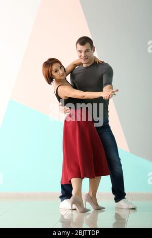 Cute loving couple dancing against light background Stock Photo - Alamy