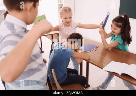 Brave little boy protecting girl from bullying in classroom Stock Photo ...