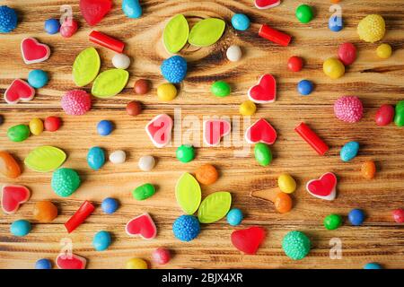 Colorful chewy candies on wooden background Stock Photo - Alamy