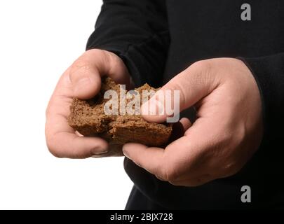 Poor man with little piece of bread on brick wall background. Black and ...