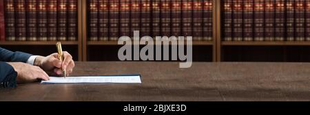 Lawyer Doing Legal Document Scrutiny At Desk With Books At Background ...