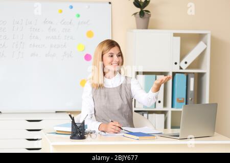 Beautiful English teacher calling out pupil during lesson in classroom ...