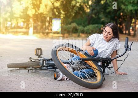 Young woman fallen off her bicycle outdoors Stock Photo - Alamy