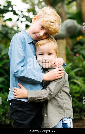 Smiling brothers hugging outdoors Stock Photo - Alamy