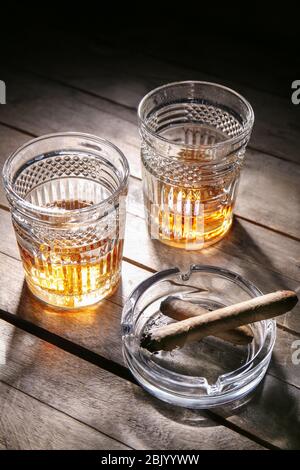 Glasses of cold whiskey with cigars on wooden table Stock Photo - Alamy