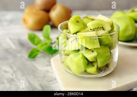 Container with tasty ripe kiwi on table, closeup Stock Photo - Alamy