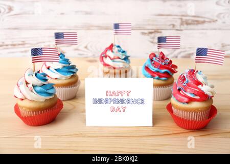 Tasty patriotic cupcakes and card for Independence Day on table Stock ...